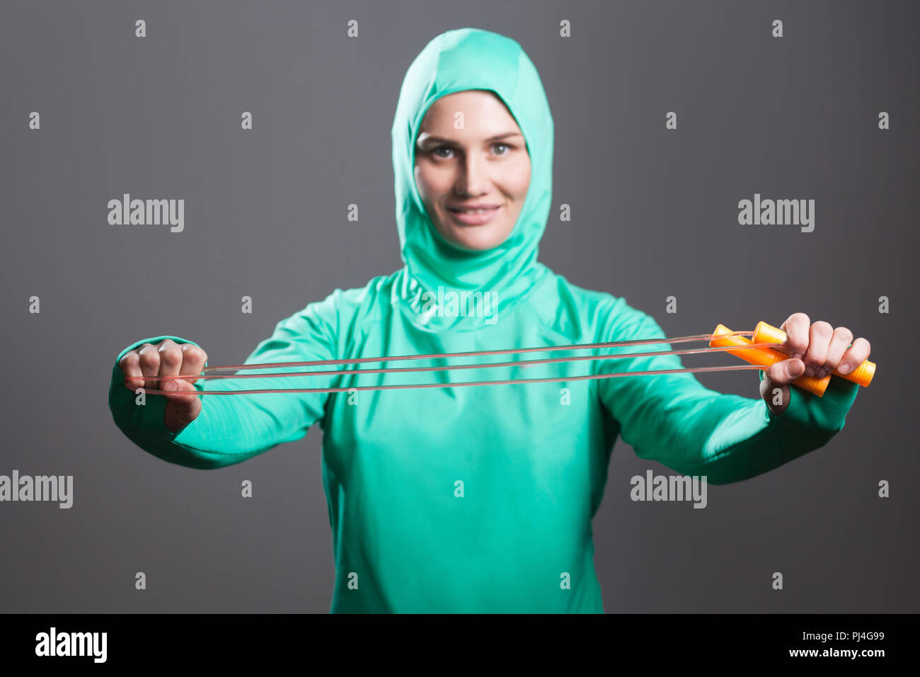 Happy beautiful muslim woman in green hijab or islamic sport wear ...