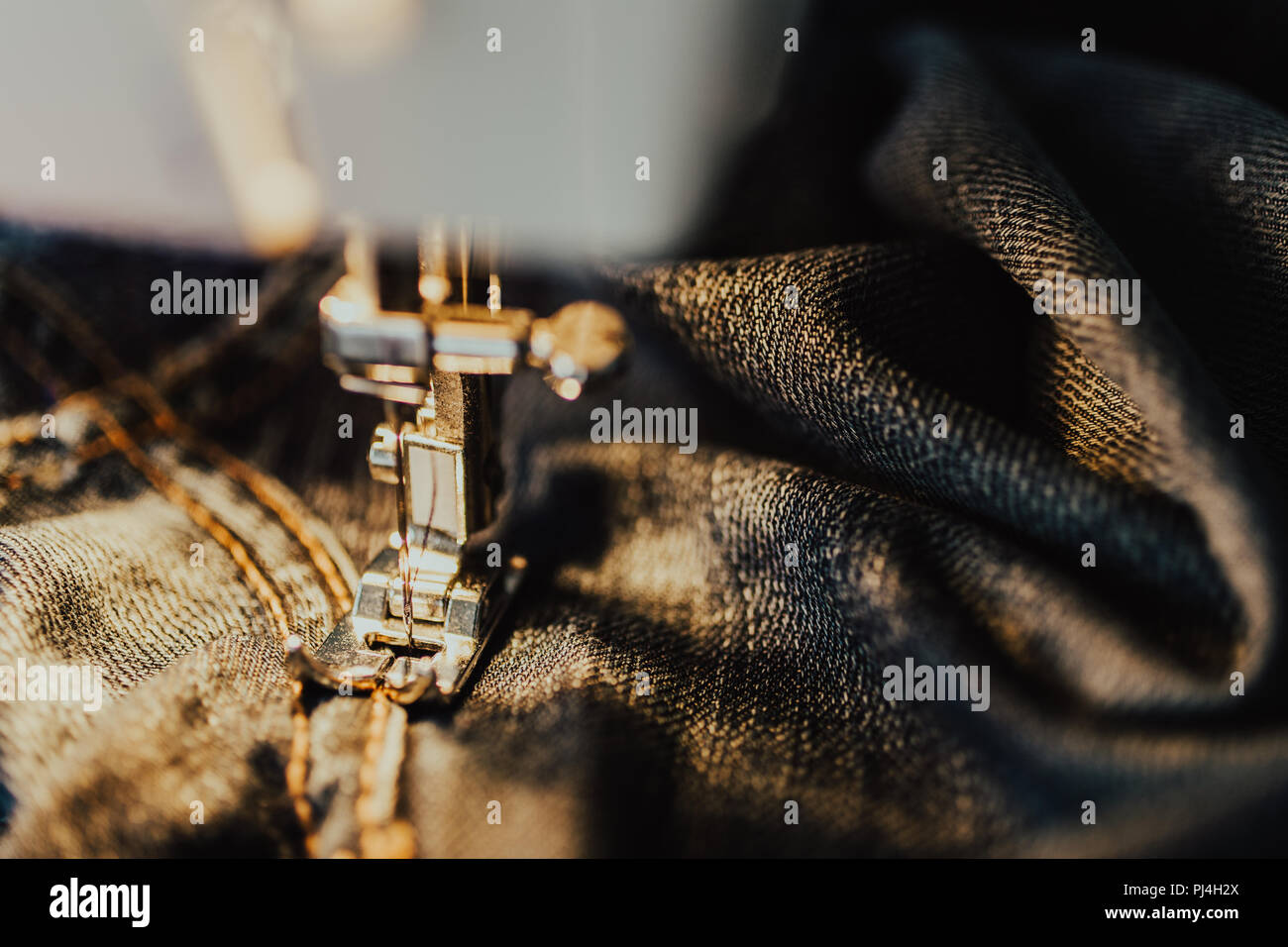 Repair jeans on the sewing machine. View of the fabric, needle and ...