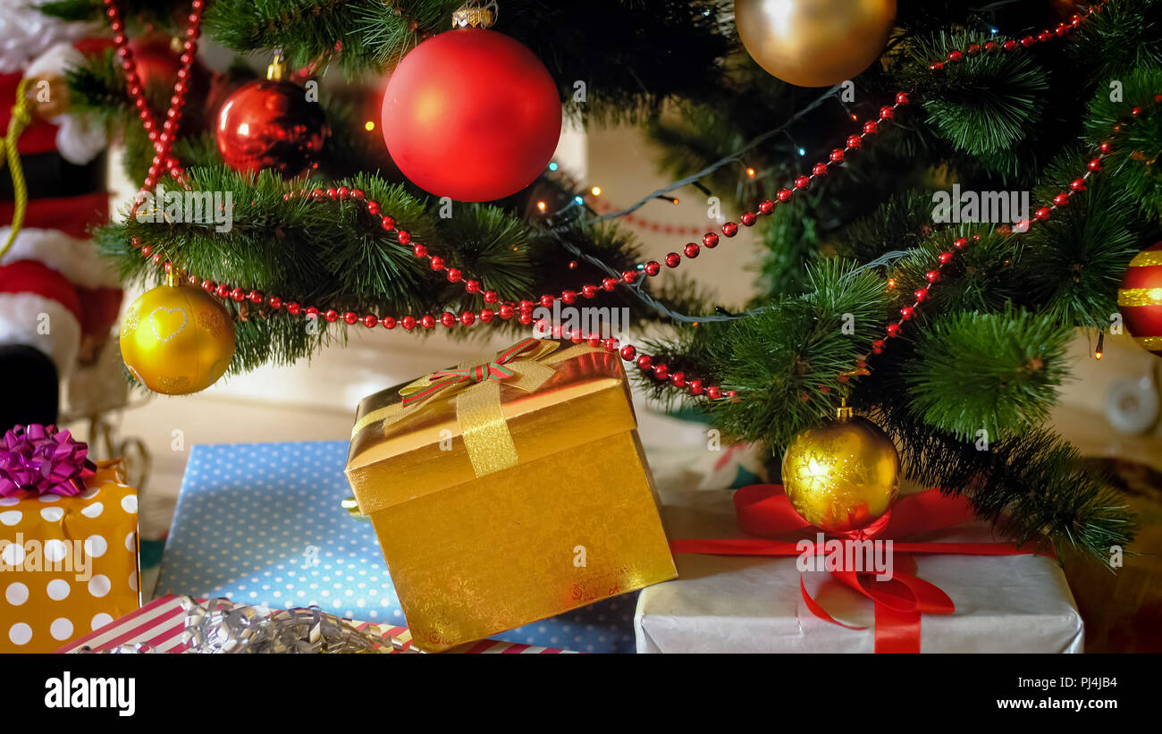 Closeup photo of lots of gift boxes lying under Christmas tree at ...