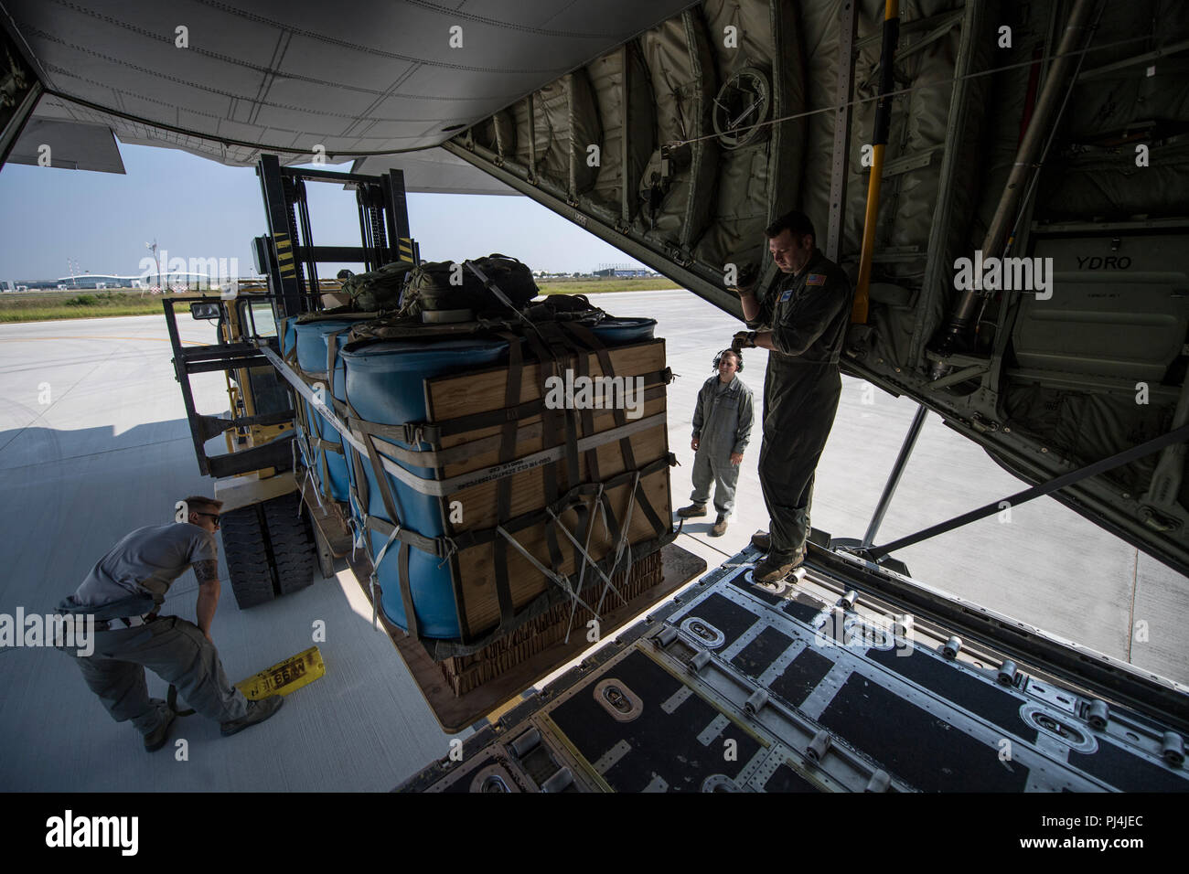 Romanian air force and U.S. Air Force personnel load container delivery ...