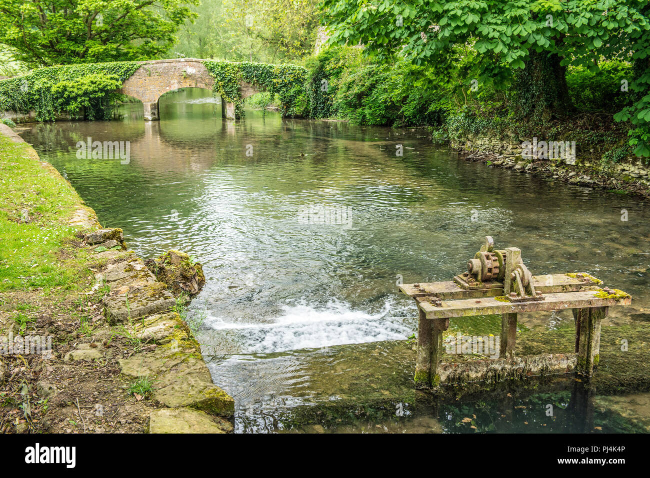 The River Eye at Lower Slaughter in the Cotswolds showing a stone ...