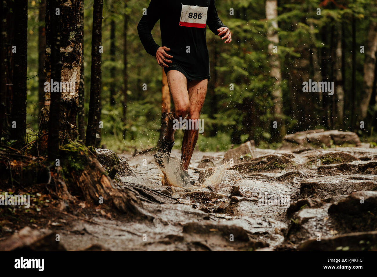athlete runner with dirty legs running on puddle of water spray Stock ...