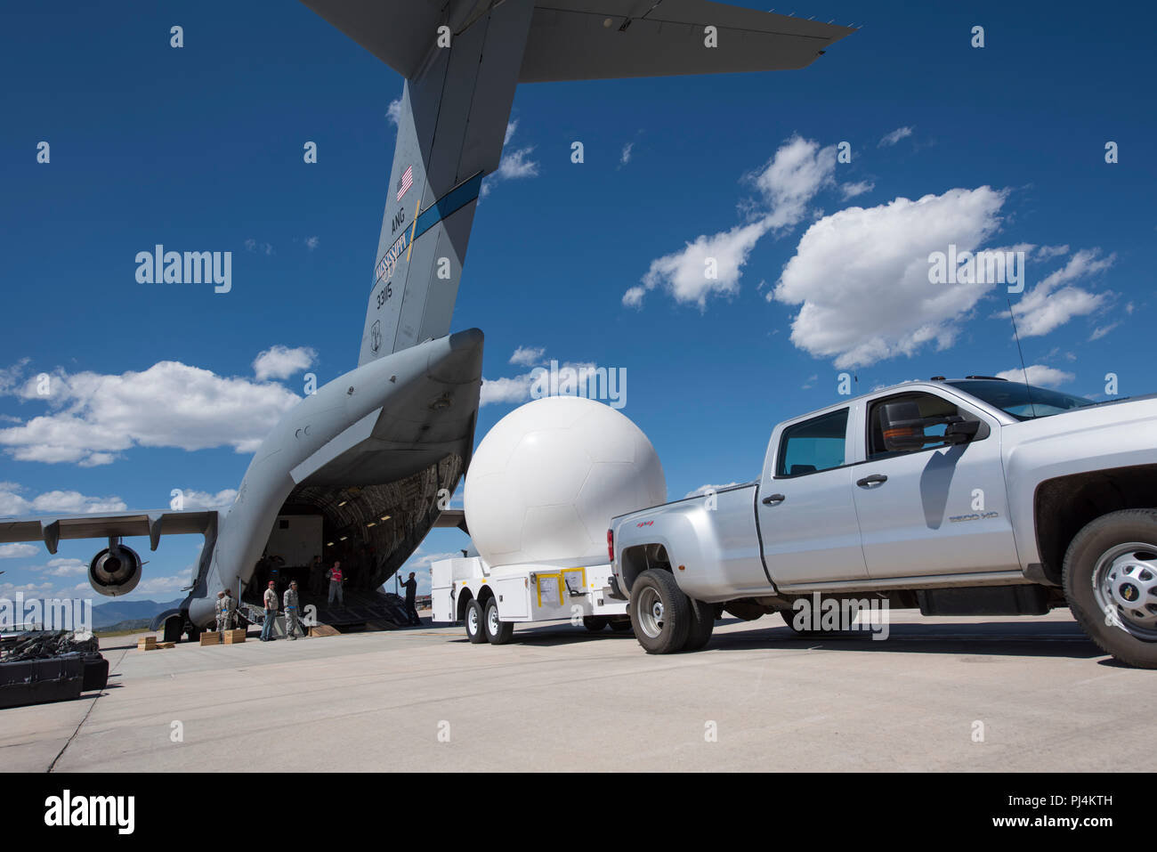 A truck loads a Low Profile Antenna onto a C-17 Globemaster III during ...
