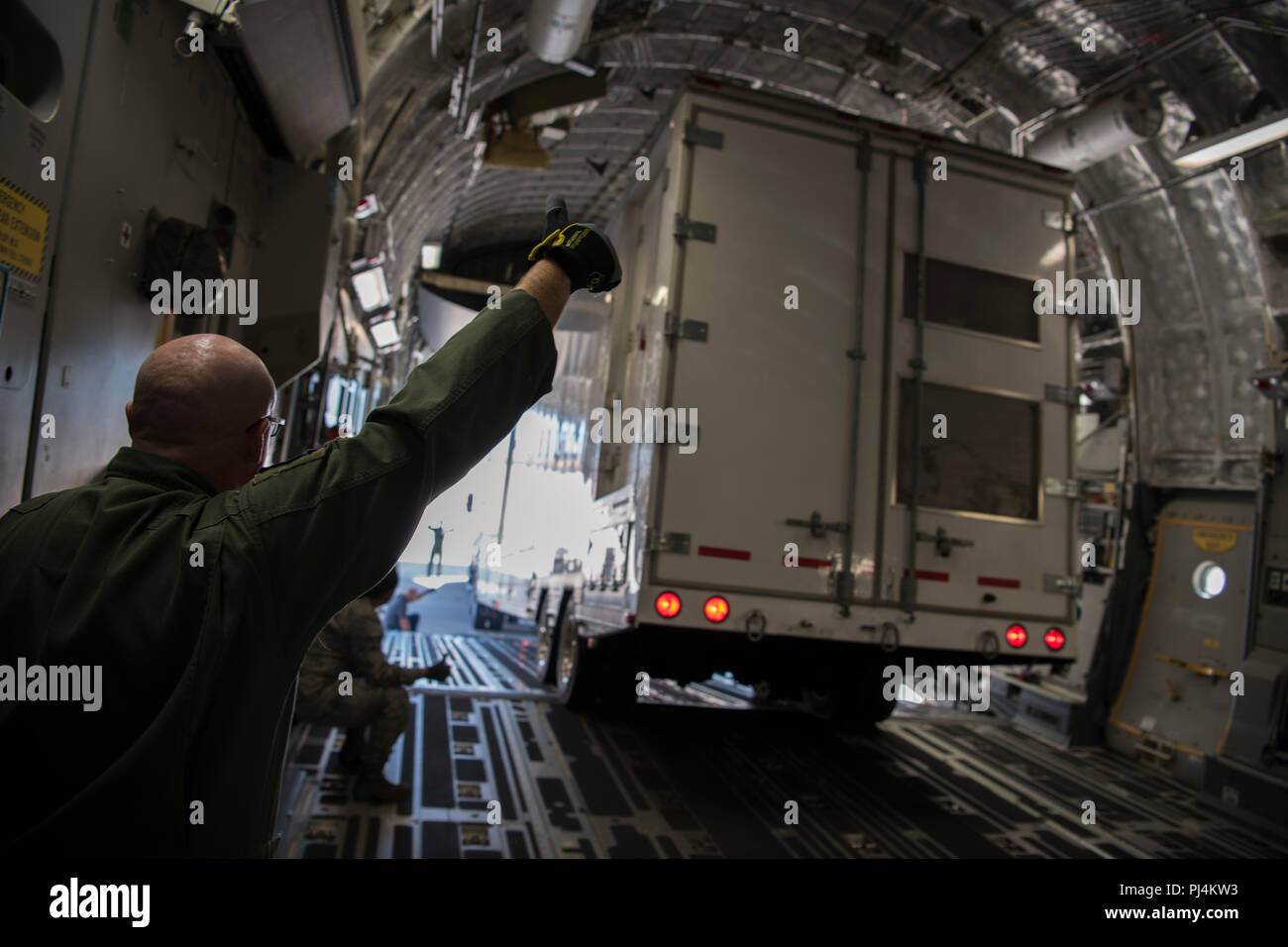 An Airman signals to a truck driver loading a Mobile Command and ...