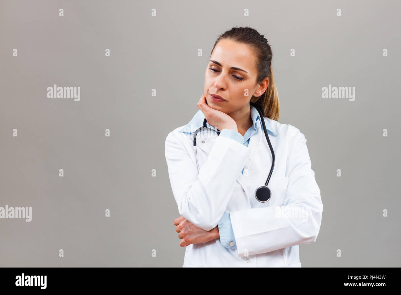 Sad female doctor thinking Stock Photo - Alamy