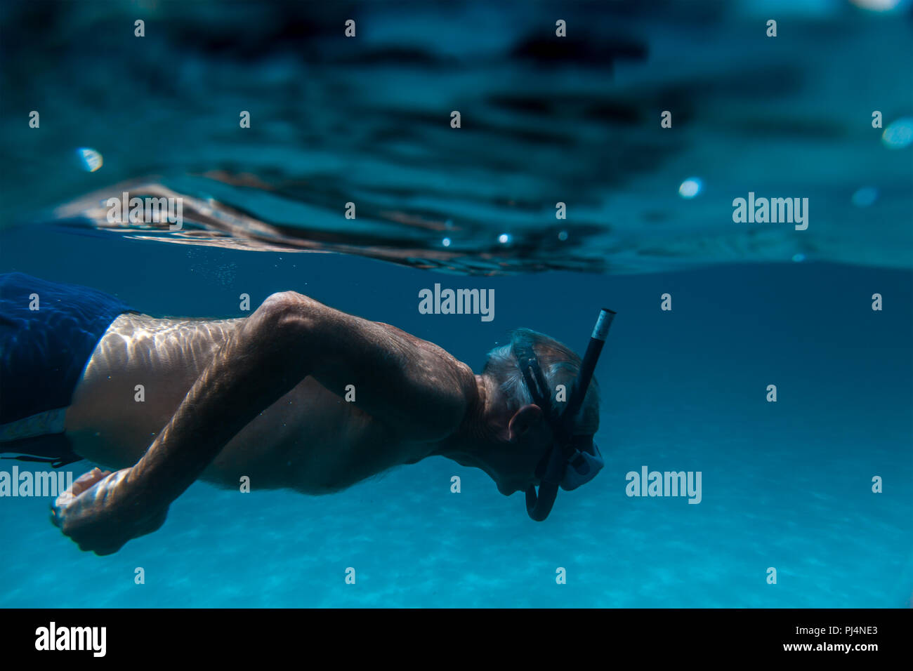 Underwater view of a Senior Man floating in beautiful ocean 70s 80s ...