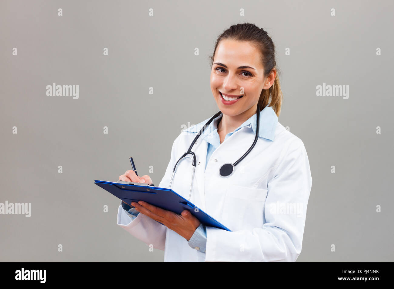 Smiling doctor holding notes hi-res stock photography and images - Alamy