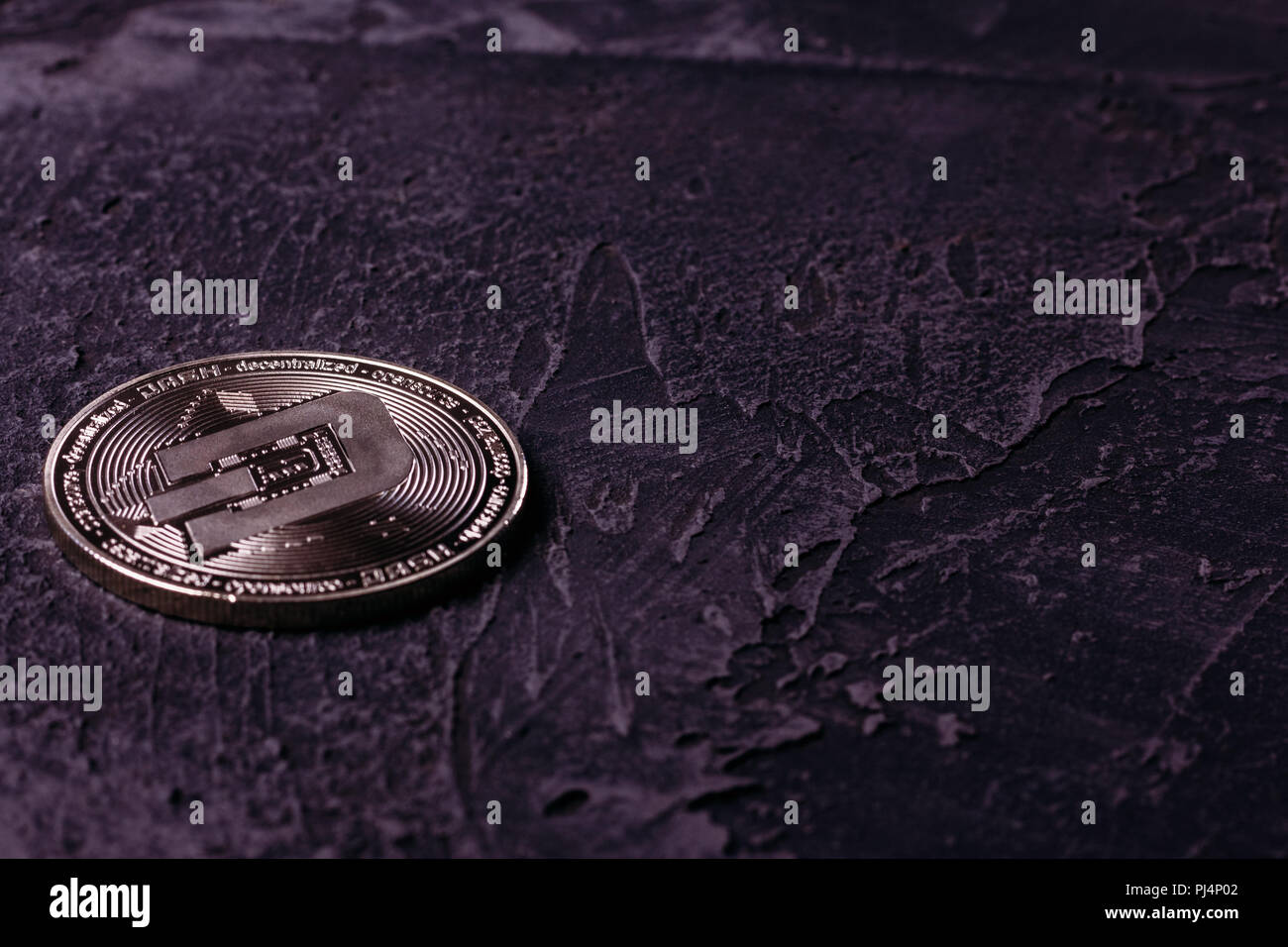 Crypto currency Dash coin on a dark concrete background with copy space ...
