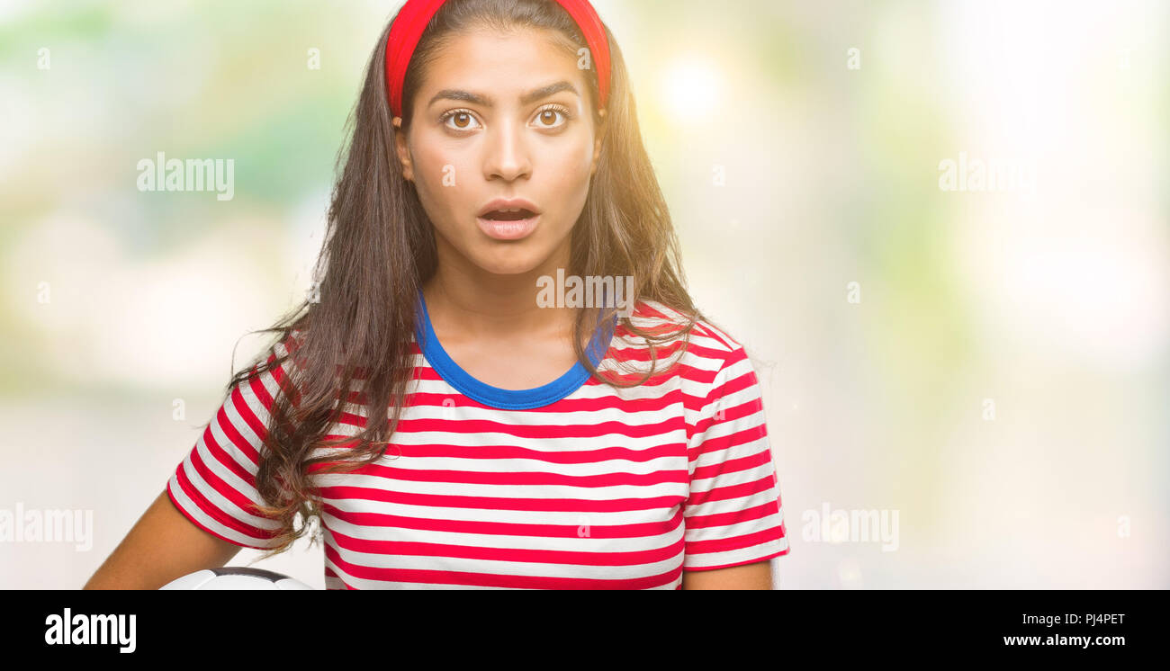 Young beautiful arab woman holding soccer football ball over isolated ...