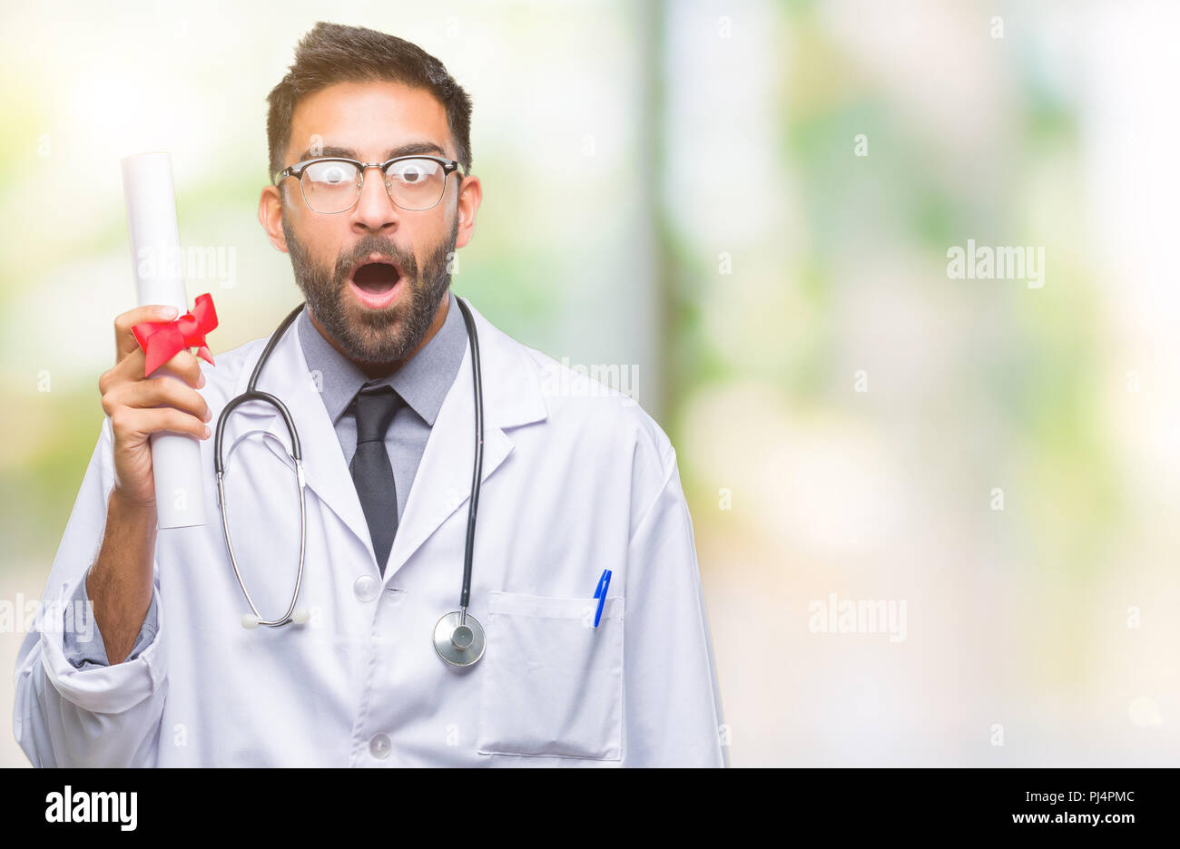 Adult hispanic doctor man holding degree over isolated background ...