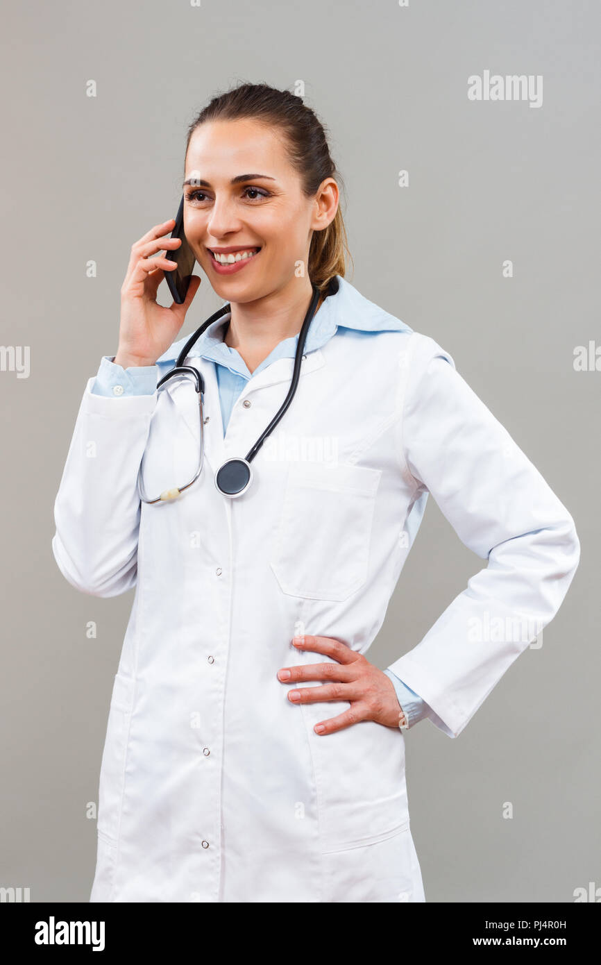 Beautiful female doctor using mobile phone Stock Photo - Alamy