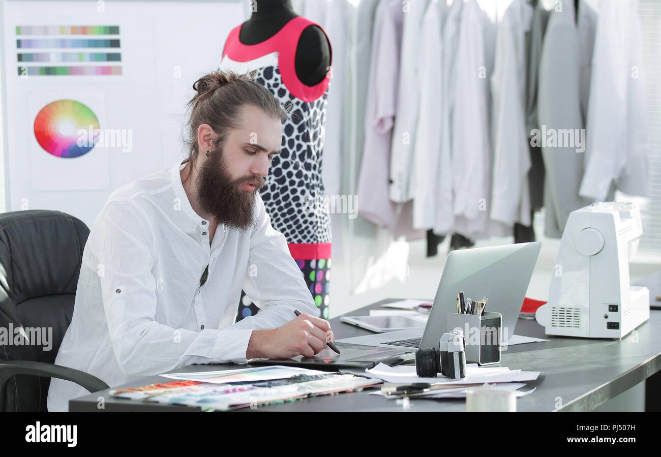 fashion designer uses a graphics tablet to create sketches of clothes ...
