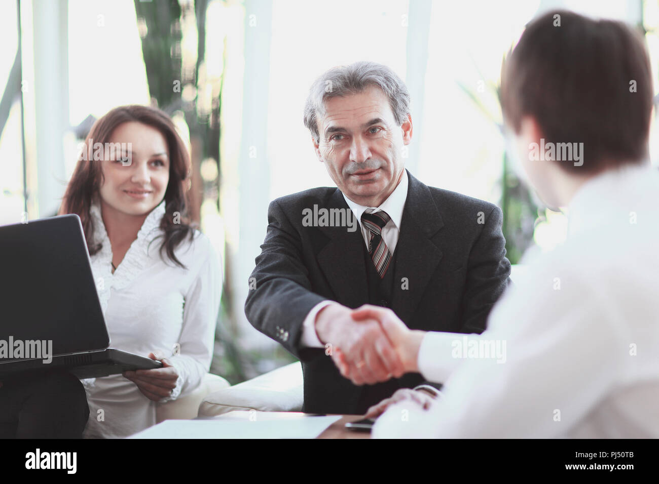 closeup. handshake Manager and client sitting at Desk Stock Photo - Alamy