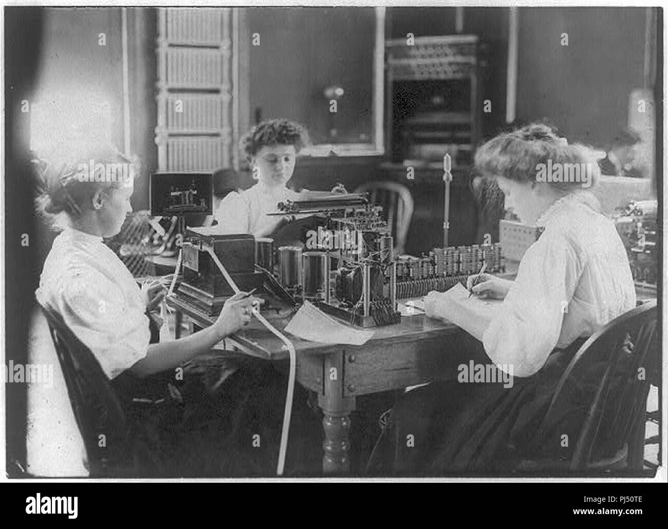 Barclay telegraph instruments. Showing instruments on stand with women ...