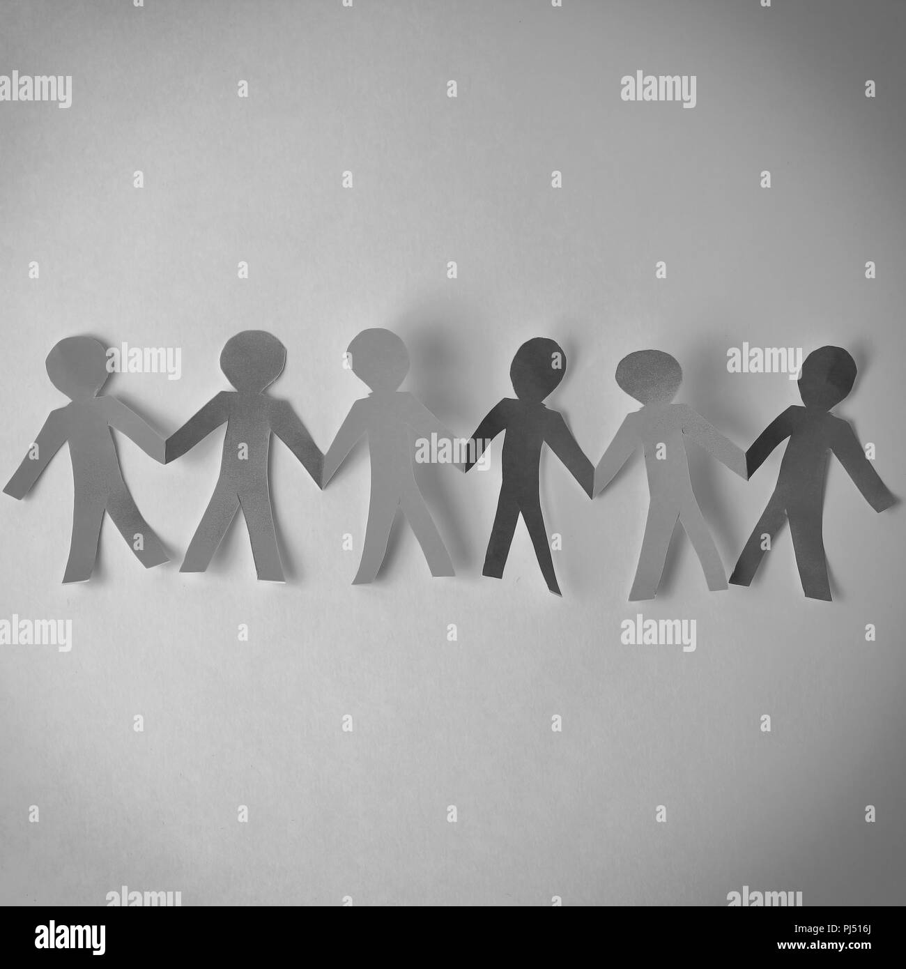 team paper men taking each other's hands Stock Photo - Alamy