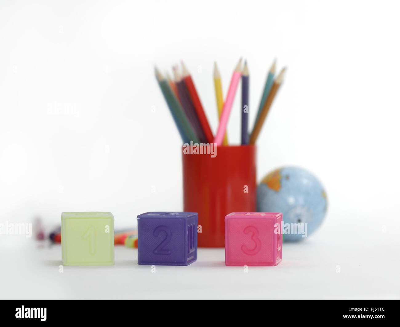 cubes with numbers on blurred school supplies background Stock Photo ...