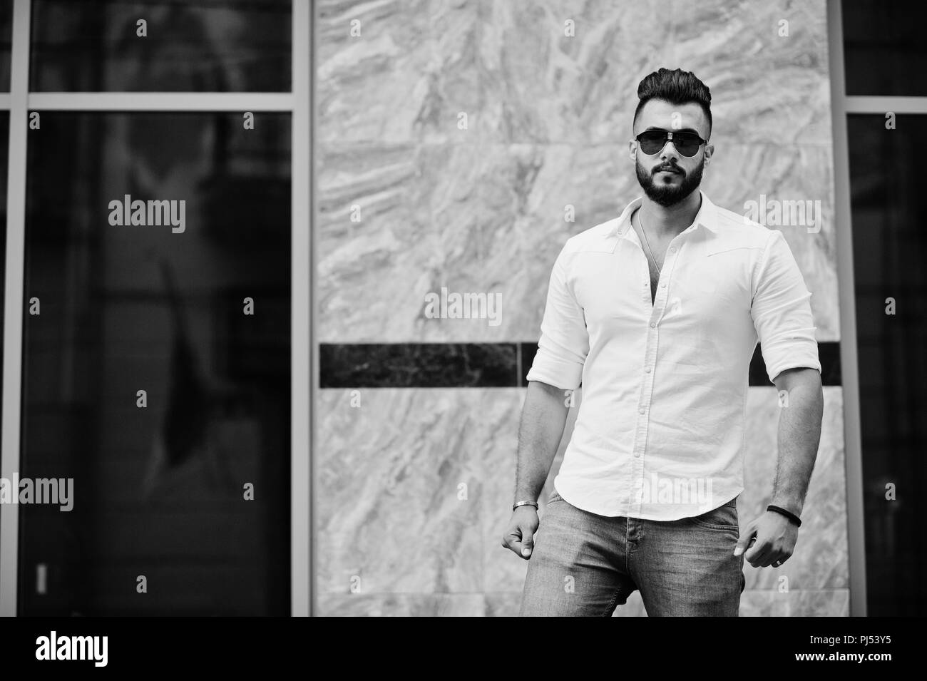 Stylish tall arabian man model in white shirt, jeans and sunglasses ...