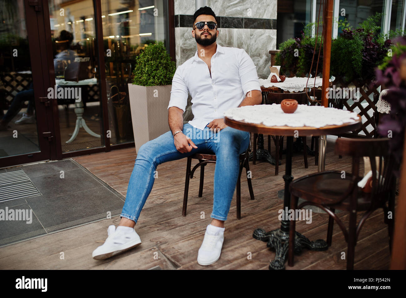 Stylish tall arabian man model in white shirt, jeans and sunglasses ...