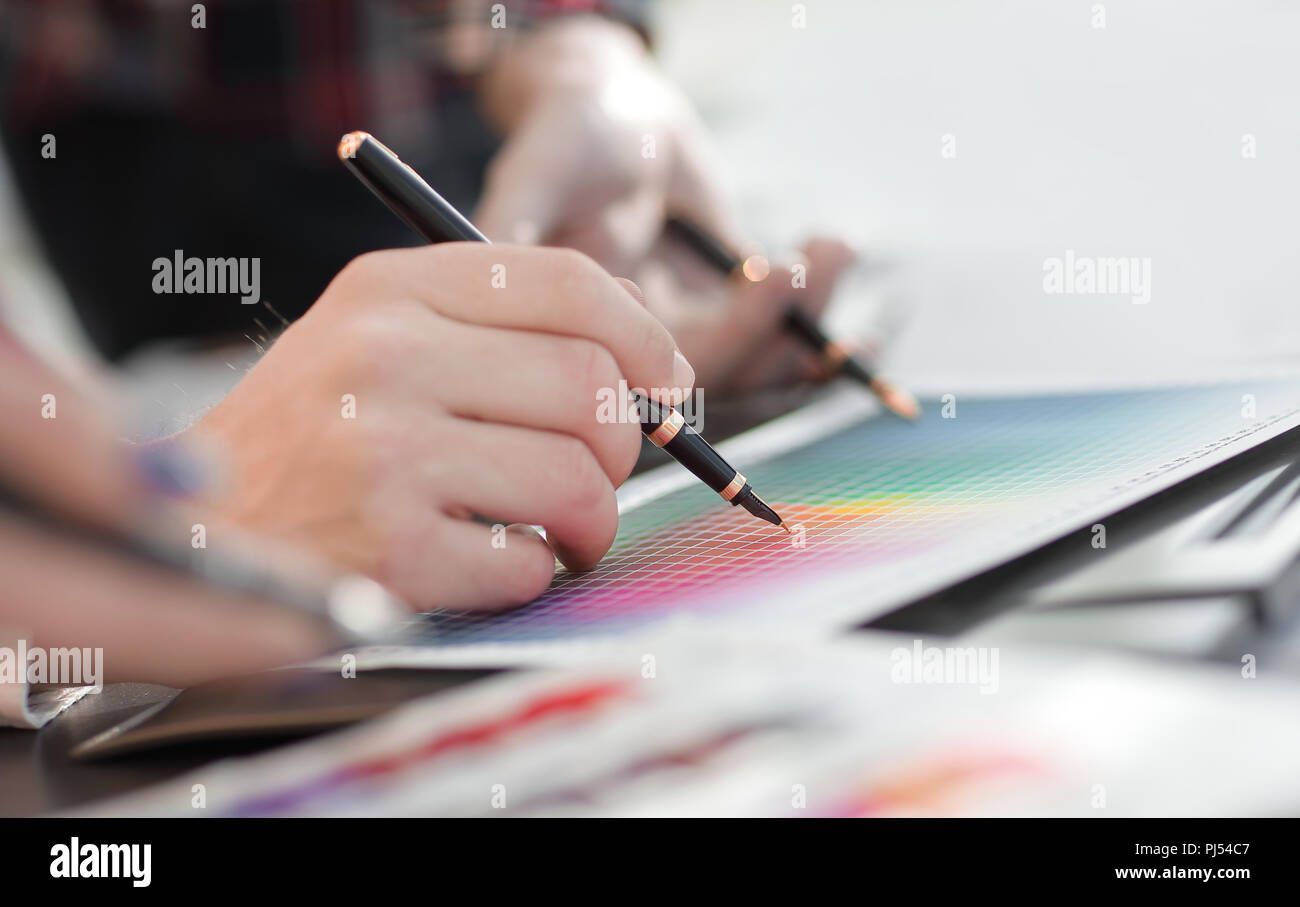 close up.a group of designers discussing the color design of a new ...
