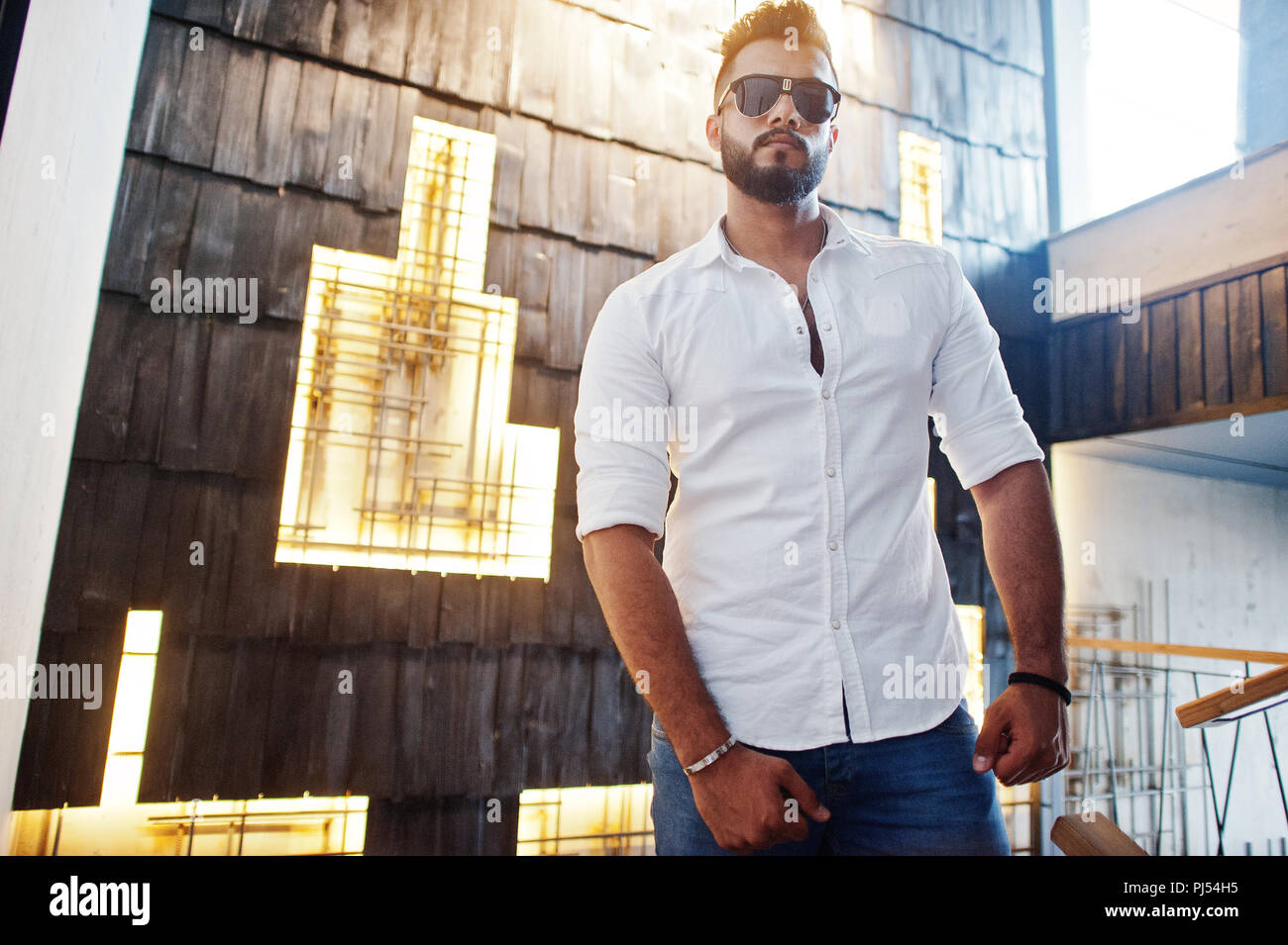 Stylish tall arabian man model in white shirt, jeans and sunglasses ...