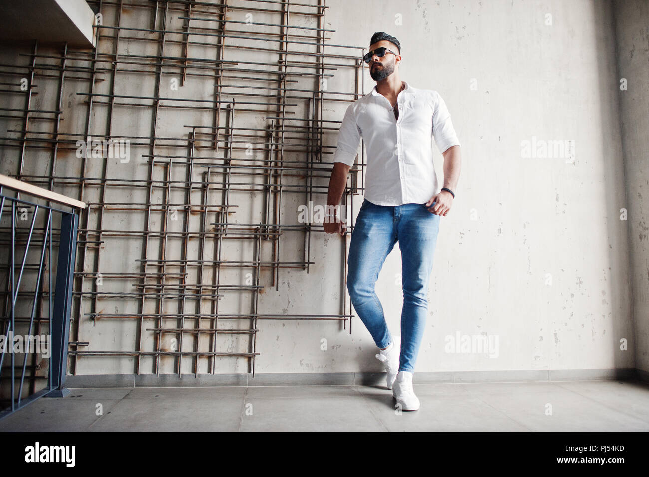 Stylish tall arabian man model in white shirt, jeans and sunglasses ...