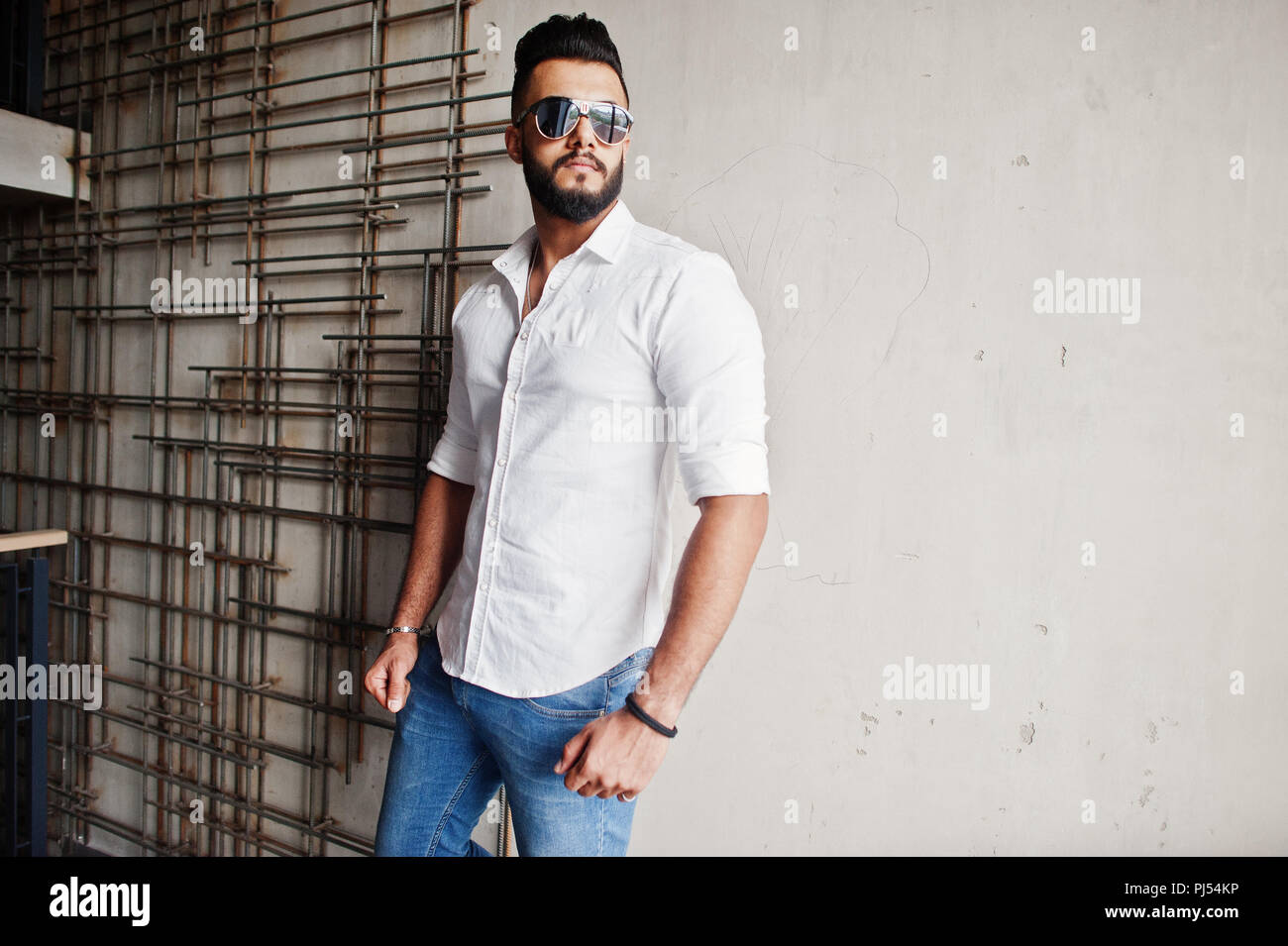 Stylish tall arabian man model in white shirt, jeans and sunglasses ...