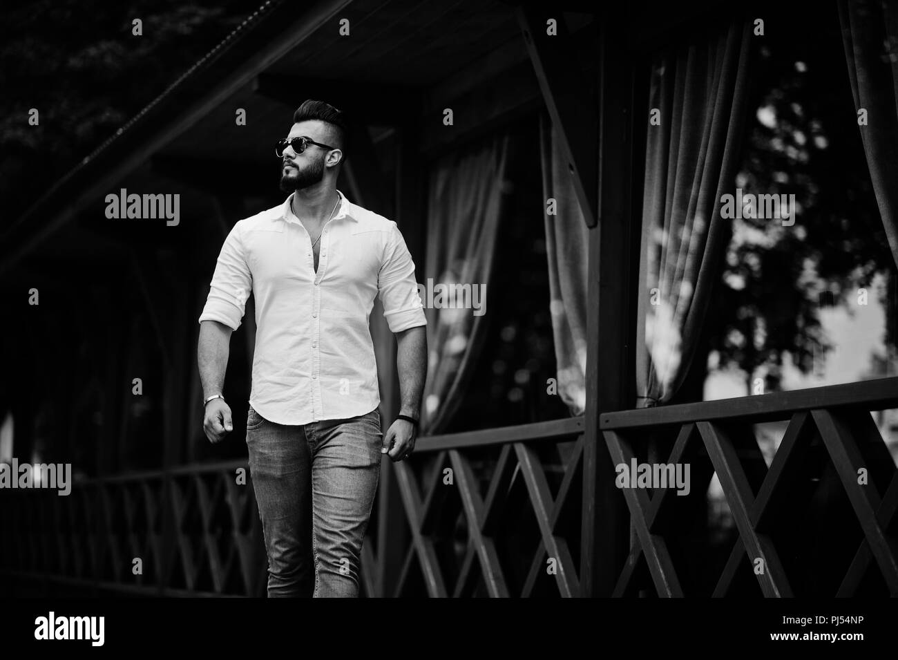 Stylish tall arabian man model in white shirt, jeans and sunglasses ...