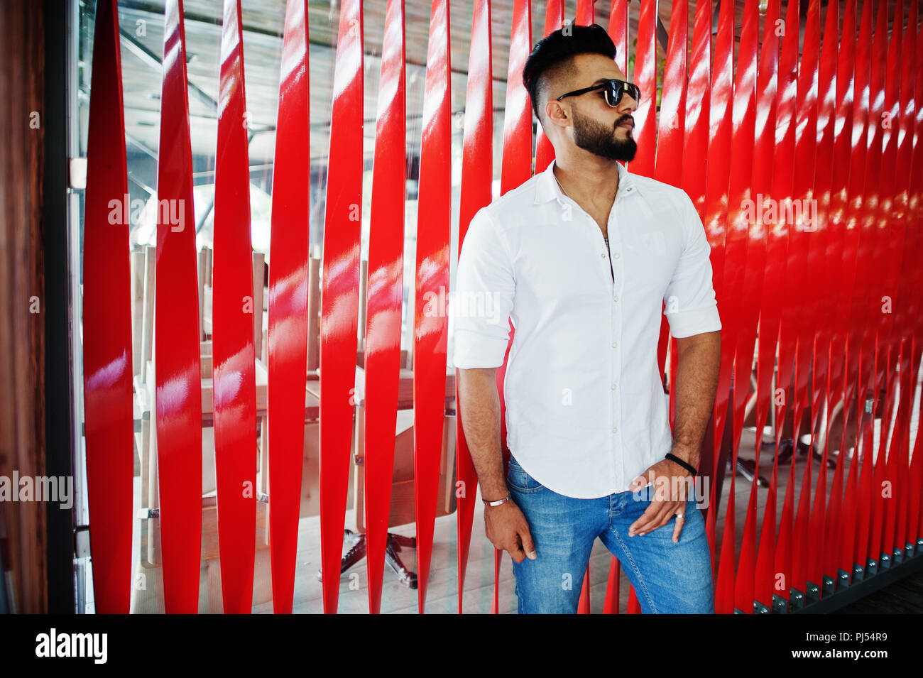 Stylish tall arabian man model in white shirt, jeans and sunglasses ...