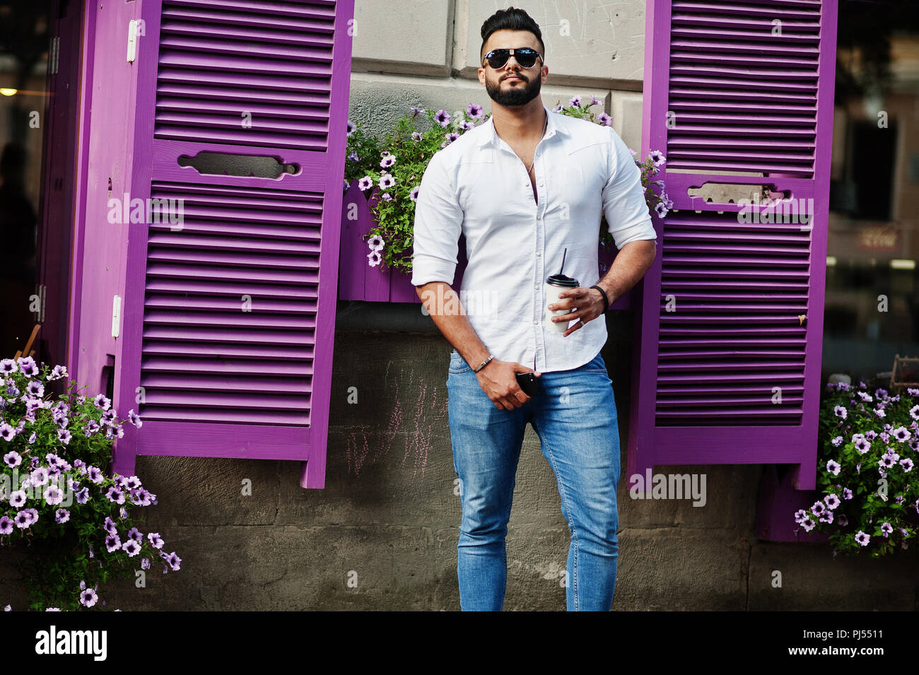 Stylish tall arabian man model in white shirt, jeans and sunglasses ...