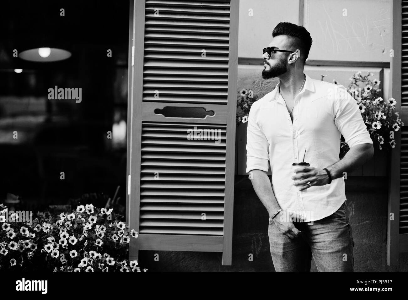 Stylish tall arabian man model in white shirt, jeans and sunglasses ...