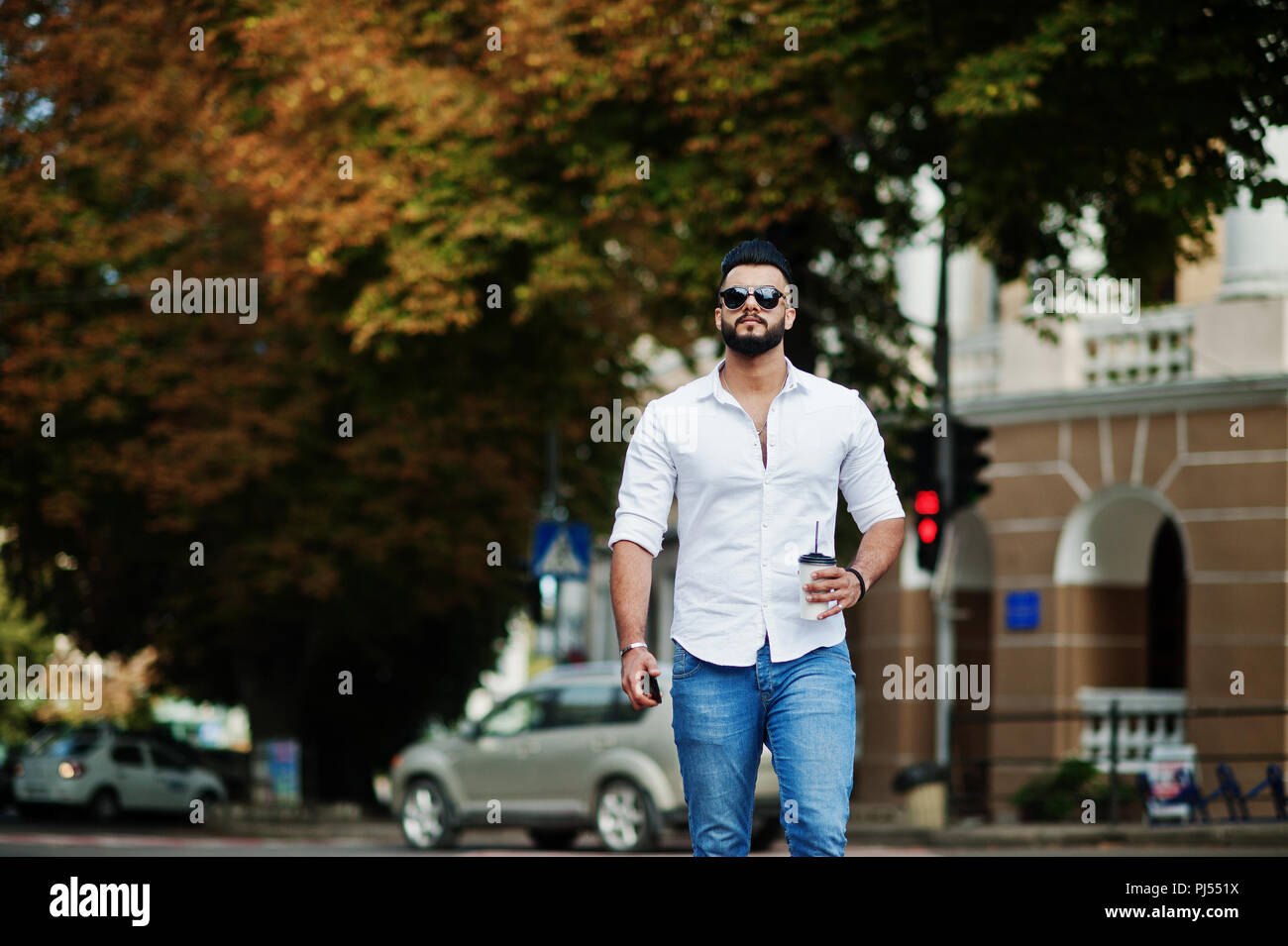 Stylish tall arabian man model in white shirt, jeans and sunglasses ...