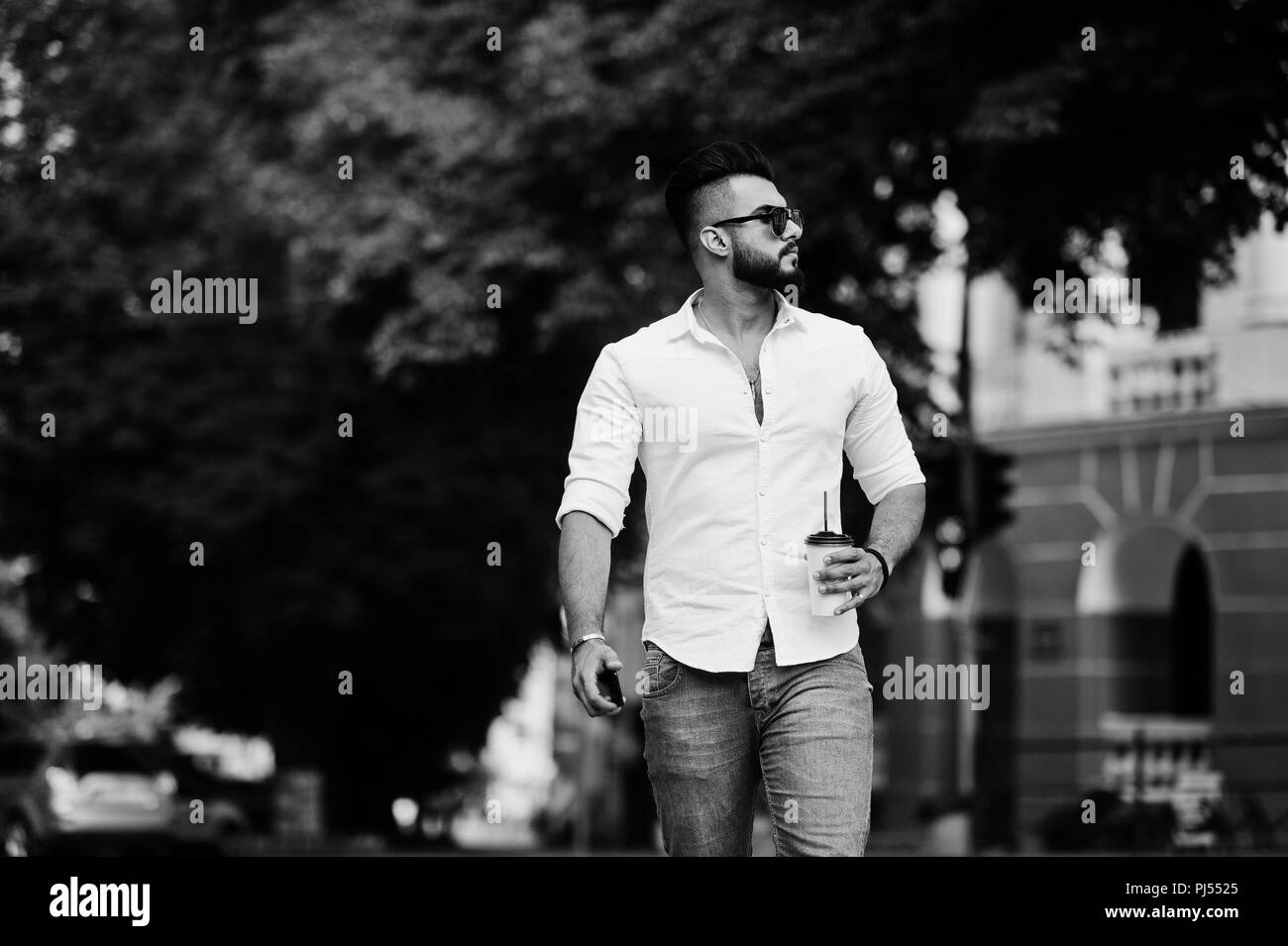 Stylish tall arabian man model in white shirt, jeans and sunglasses ...