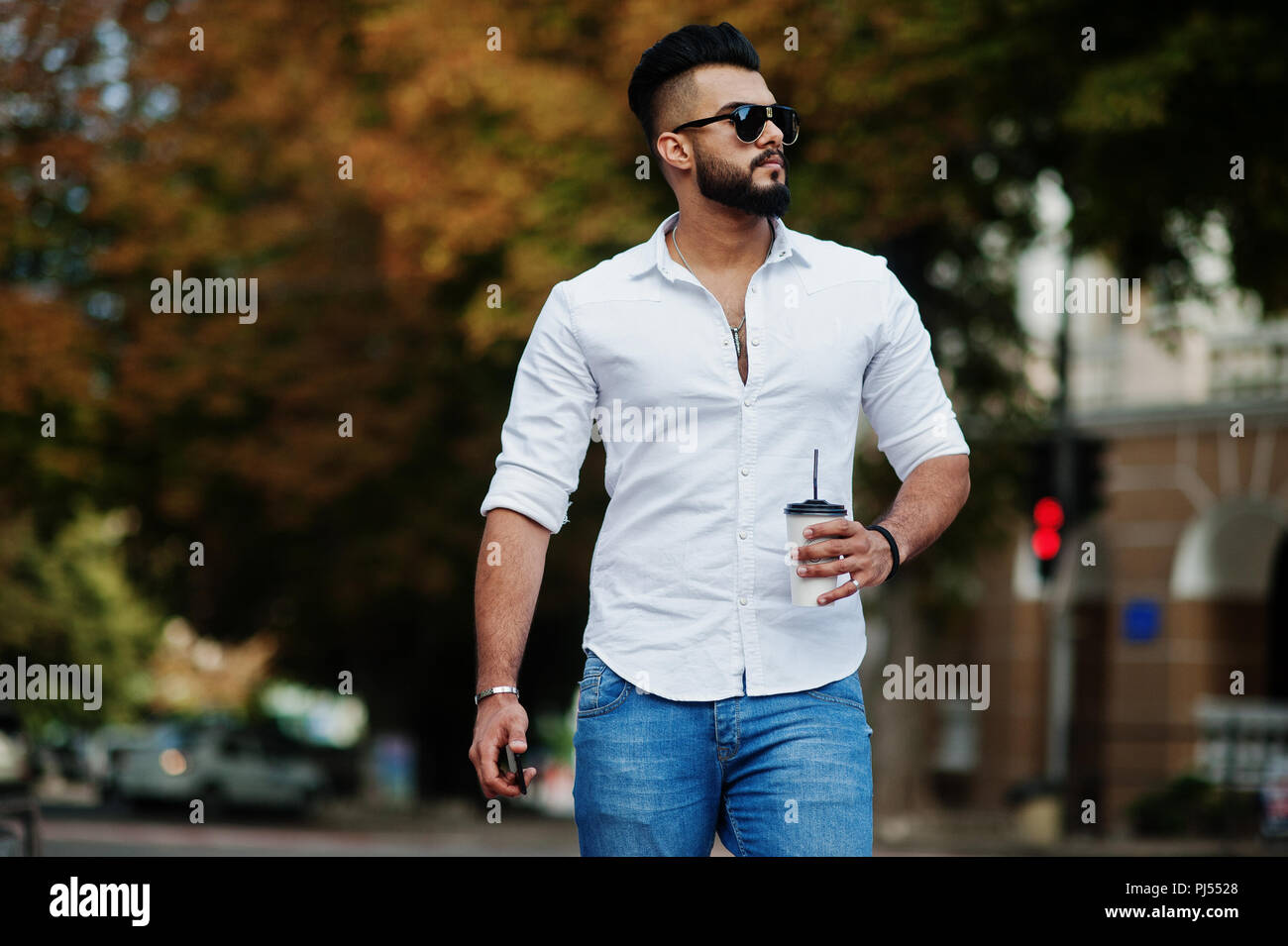 Stylish tall arabian man model in white shirt, jeans and sunglasses ...