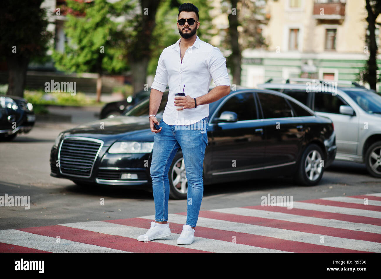 Stylish tall arabian man model in white shirt, jeans and sunglasses ...