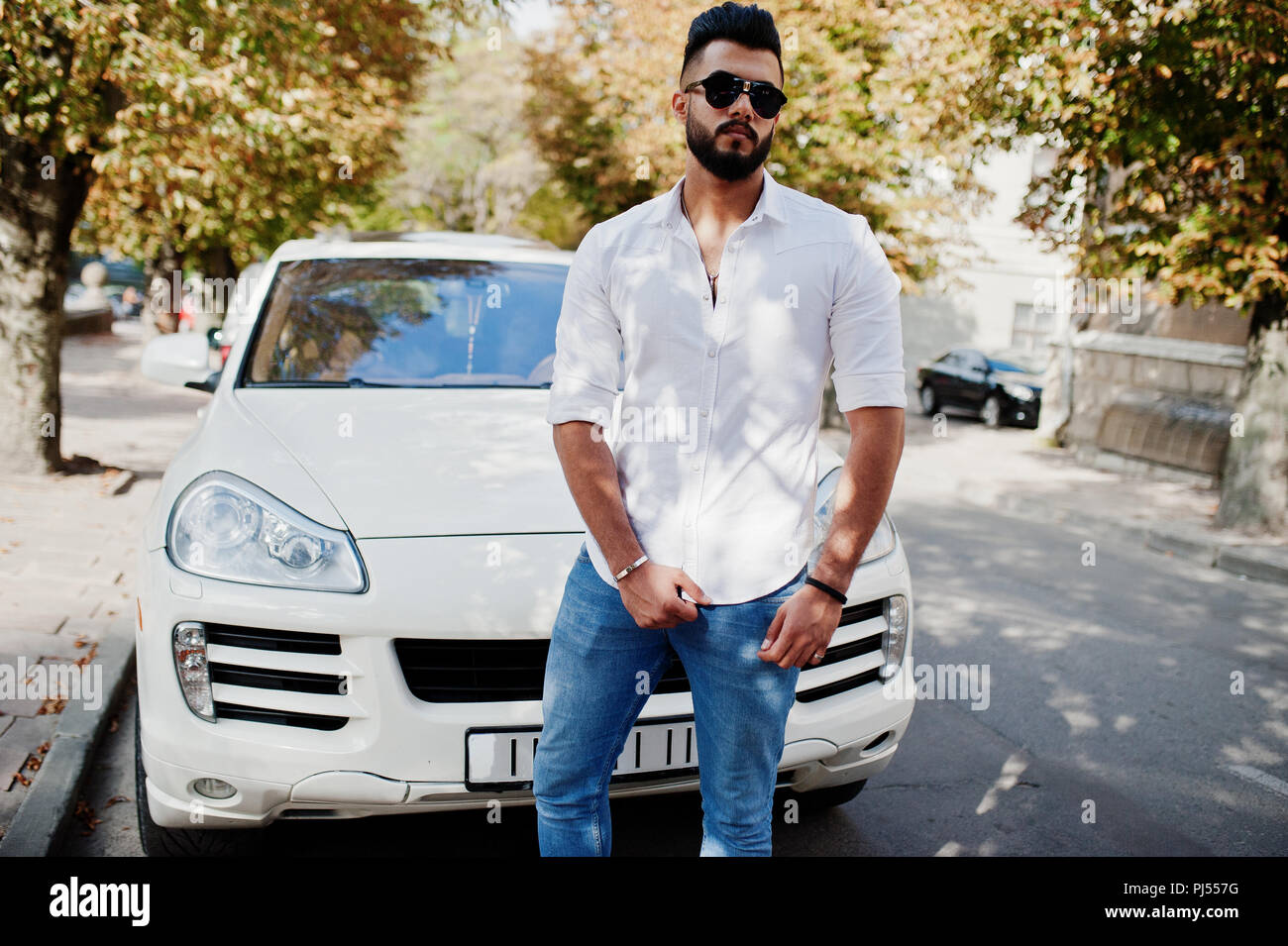 Stylish tall arabian man model in white shirt, jeans and sunglasses ...