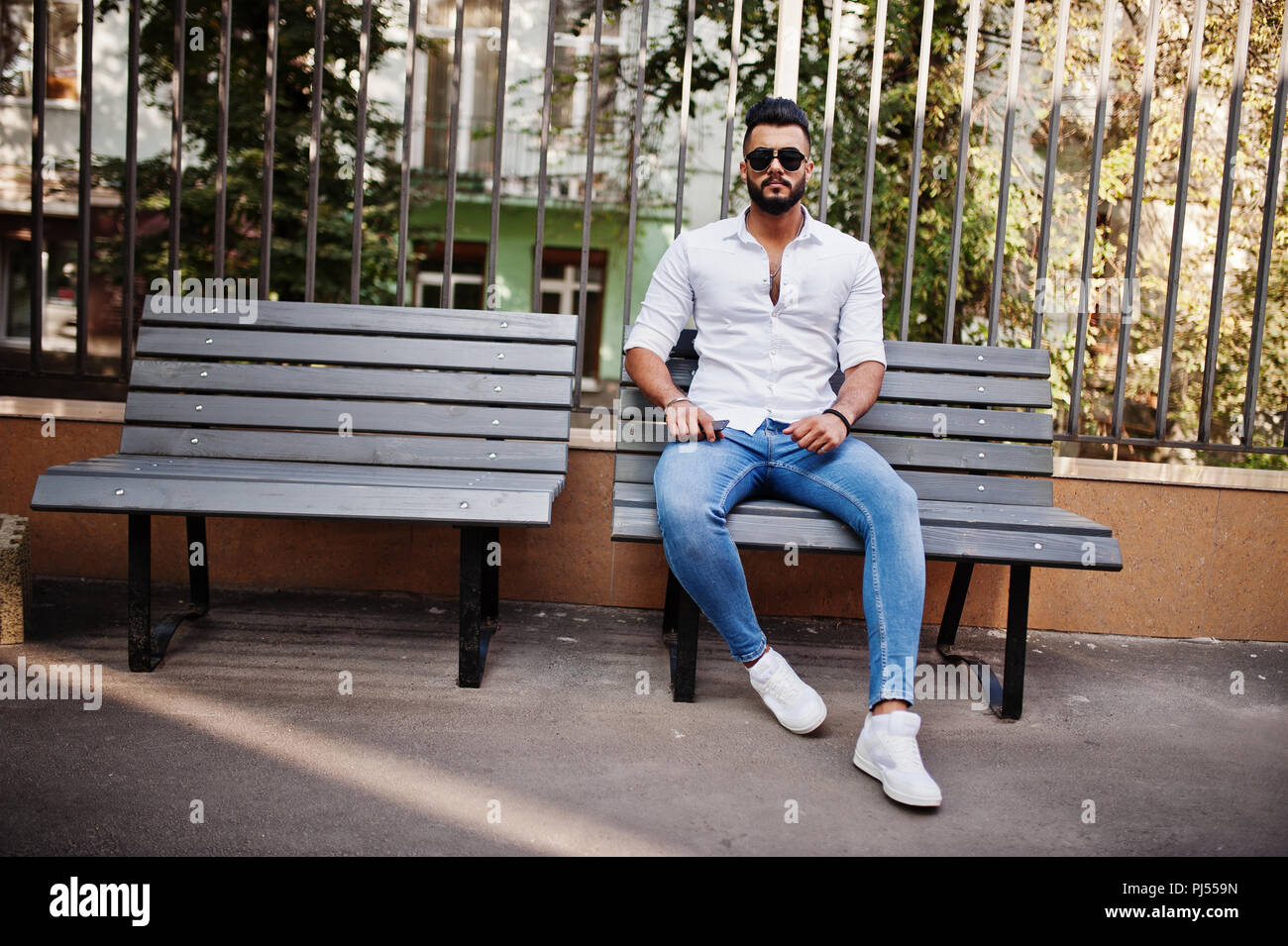 Stylish tall arabian man model in white shirt, jeans and sunglasses ...