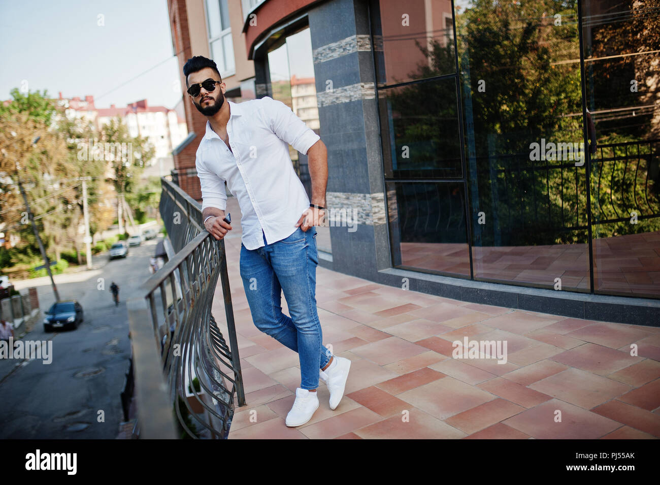 Stylish tall arabian man model in white shirt, jeans and sunglasses ...