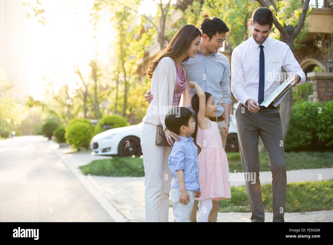 Happy young family and real estate agent Stock Photo - Alamy
