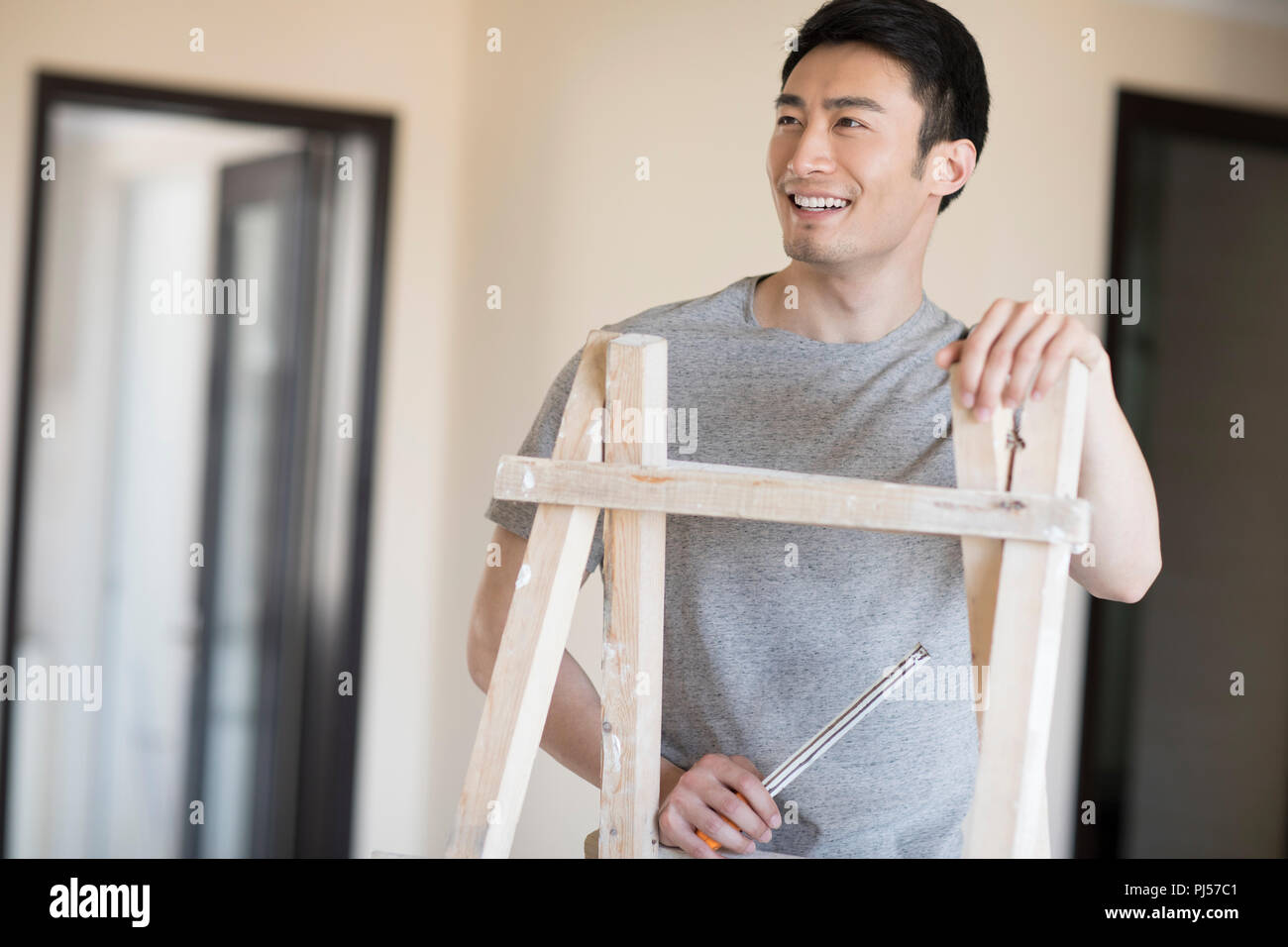 Young man working on home renovation Stock Photo - Alamy