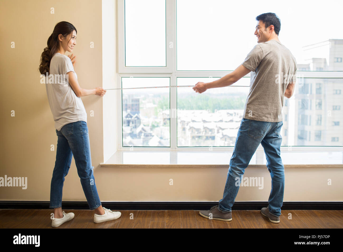 Young couple measuring window Stock Photo - Alamy
