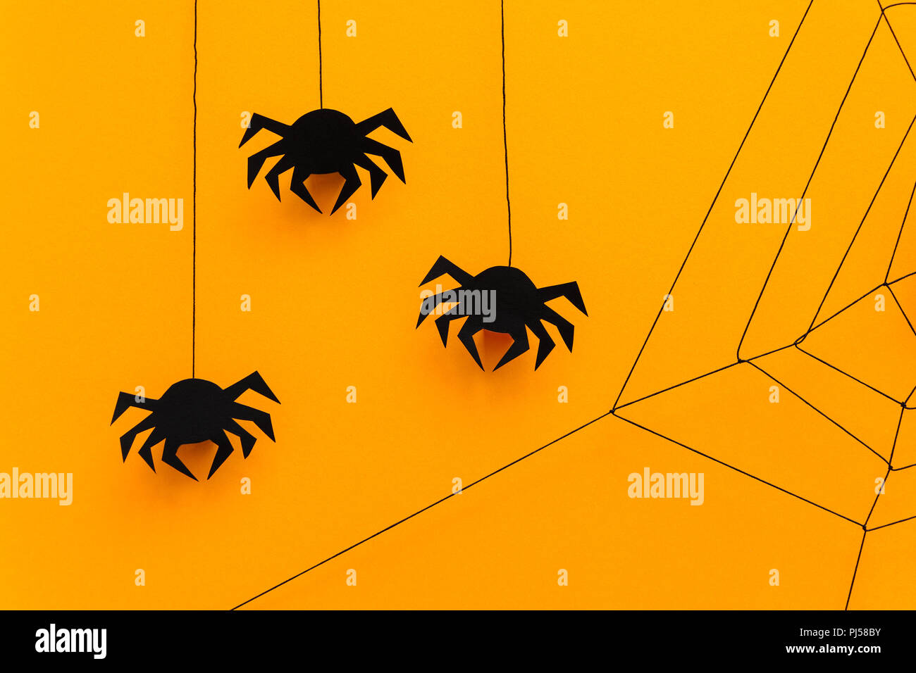 Black paper spider with web on yellow background. Halloween concept ...