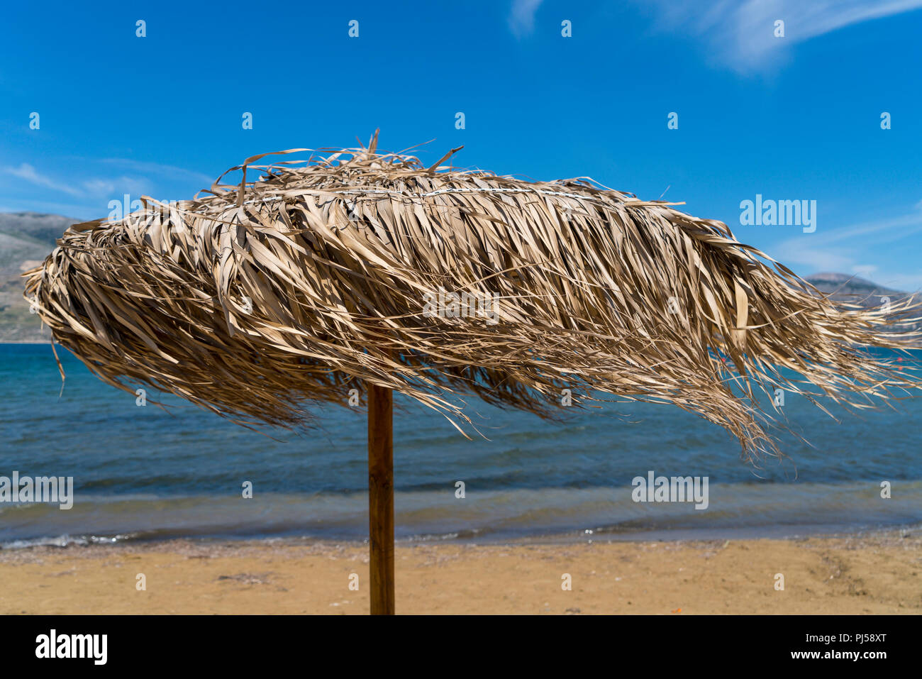 straw parasol, windy day on the beach Stock Photo - Alamy
