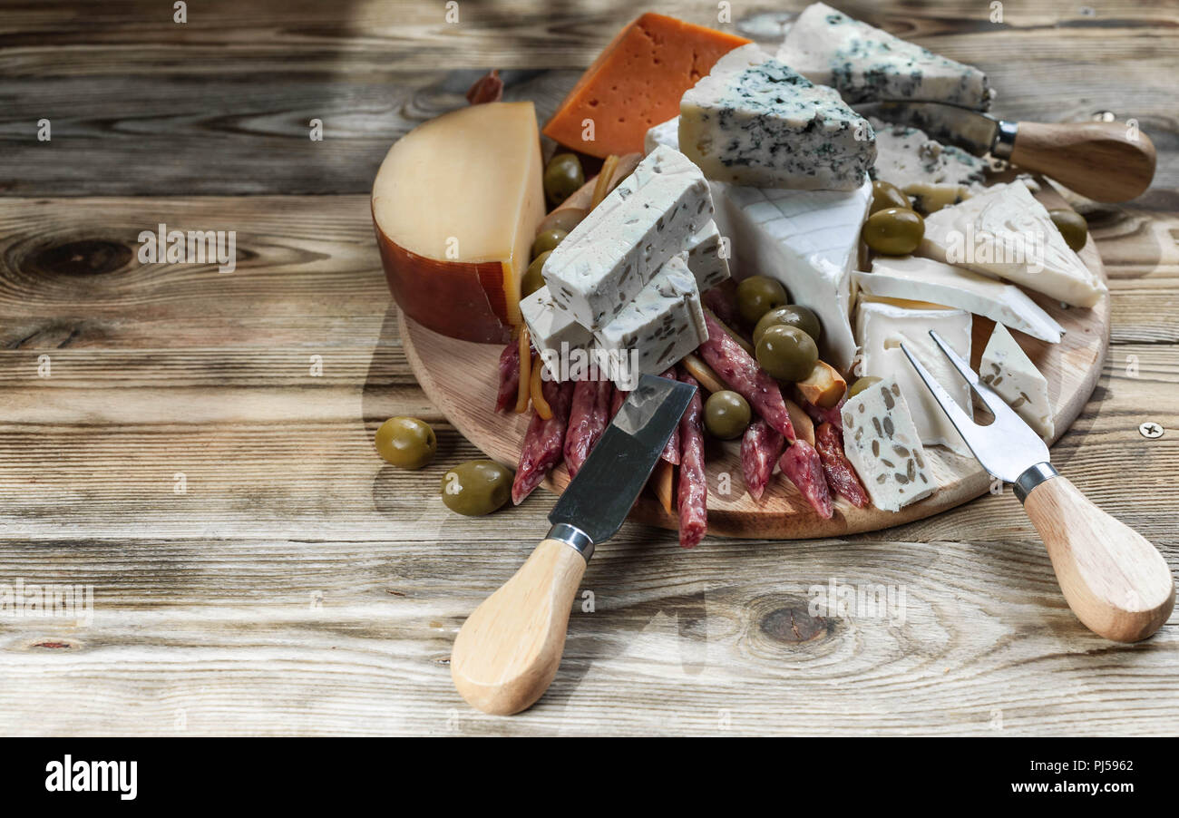 Different sorts of cheese on a wooden board Stock Photo - Alamy