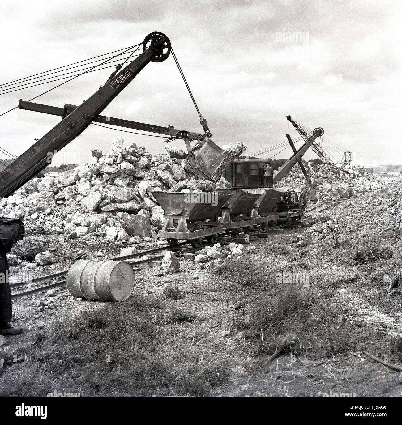 1950s, mechanical loaders moving large limestone rocks from the edge of ...