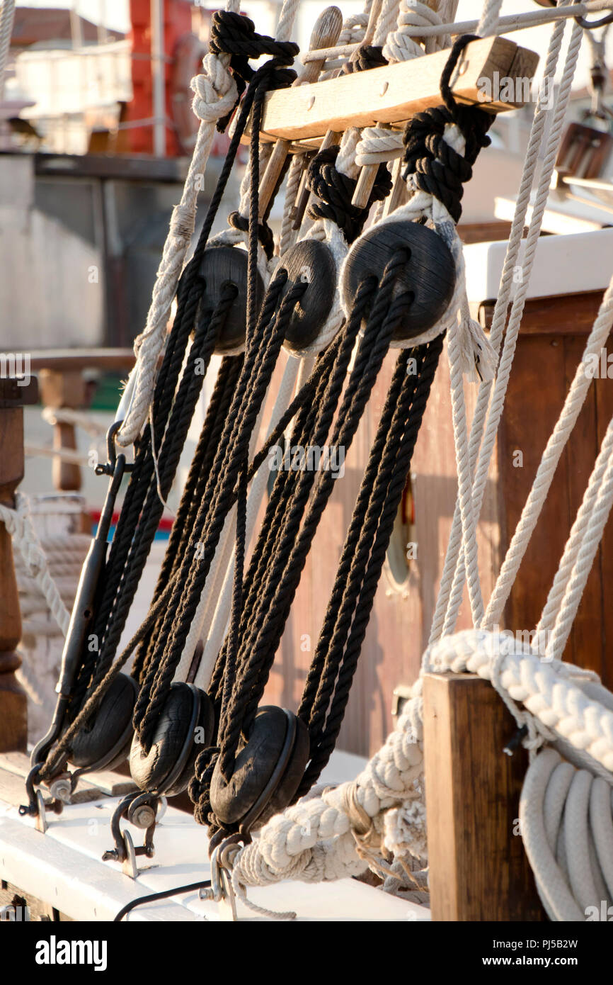 Detail of vintage sailboat wooden rigging and white and black ropes ...