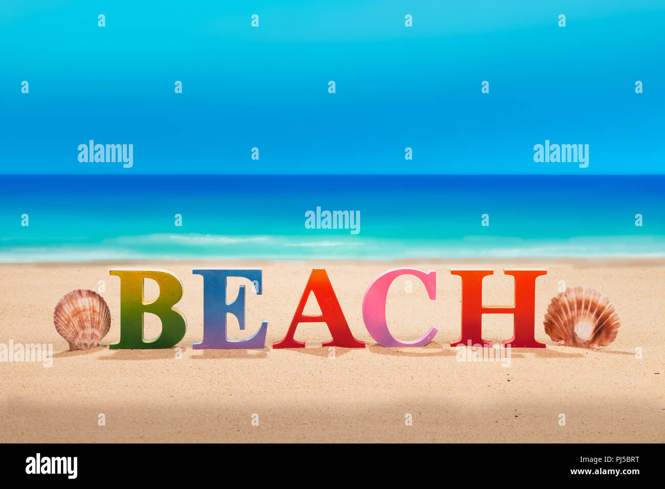 beach written in colorful wood letters with sea shell at the beach with ...