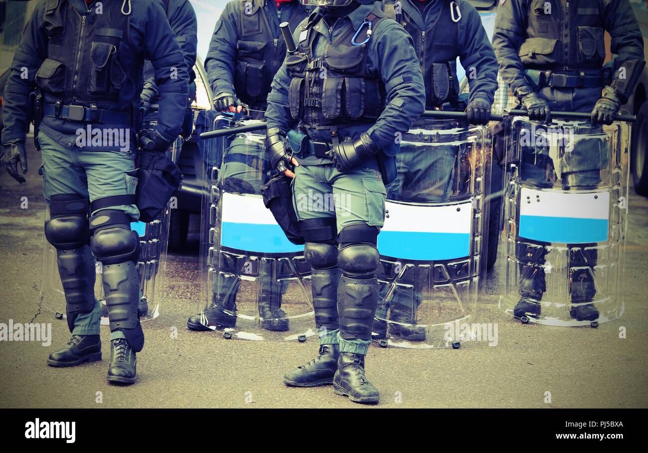 many cops in uniform with shields with vintage effect during riot in ...