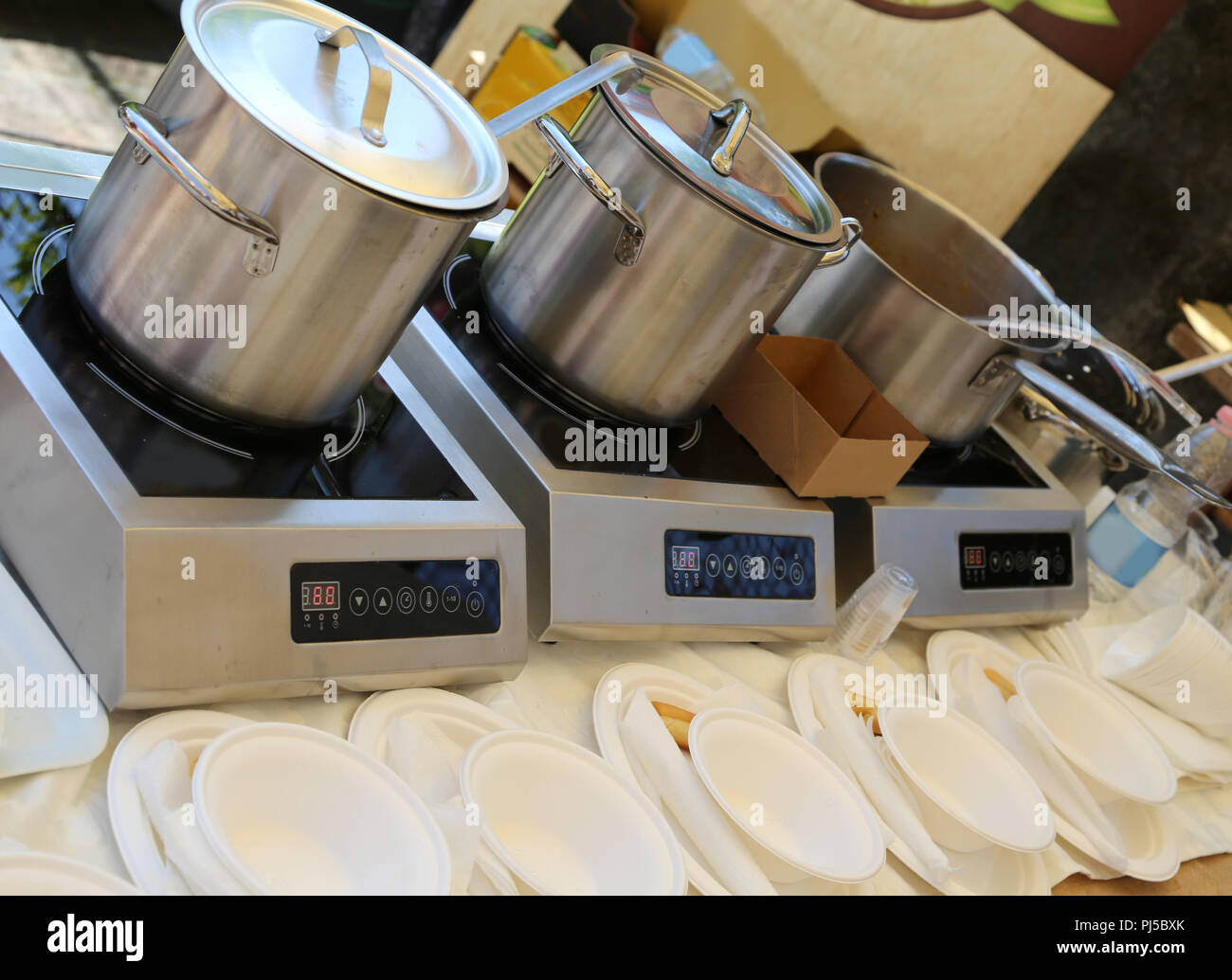 three big pots in the kitchen with plastic dishes Stock Photo - Alamy