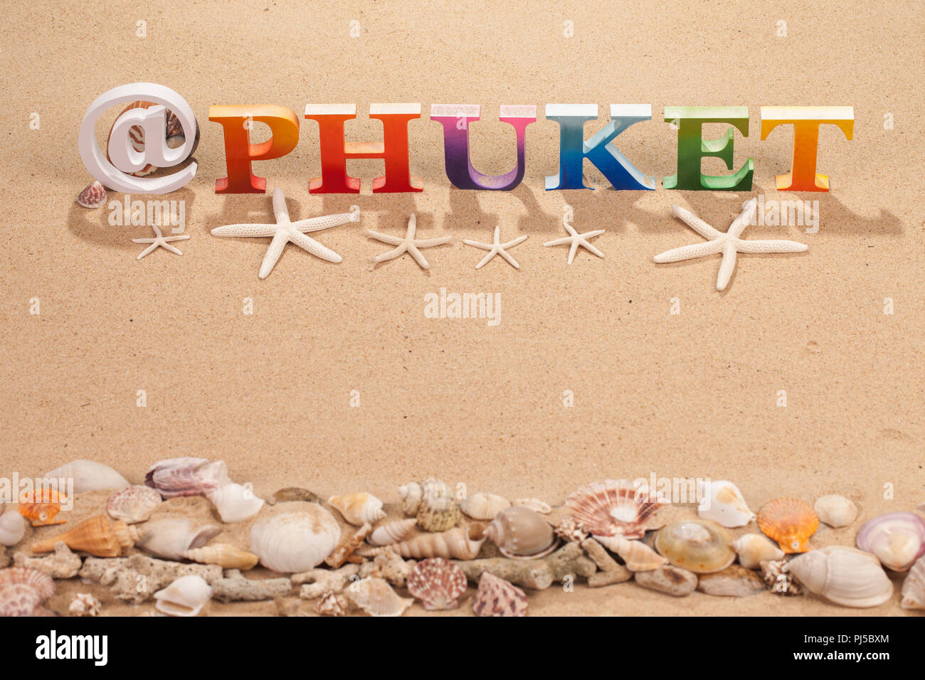@Phuket written in colorful wood letters with sea shell at the beach ...