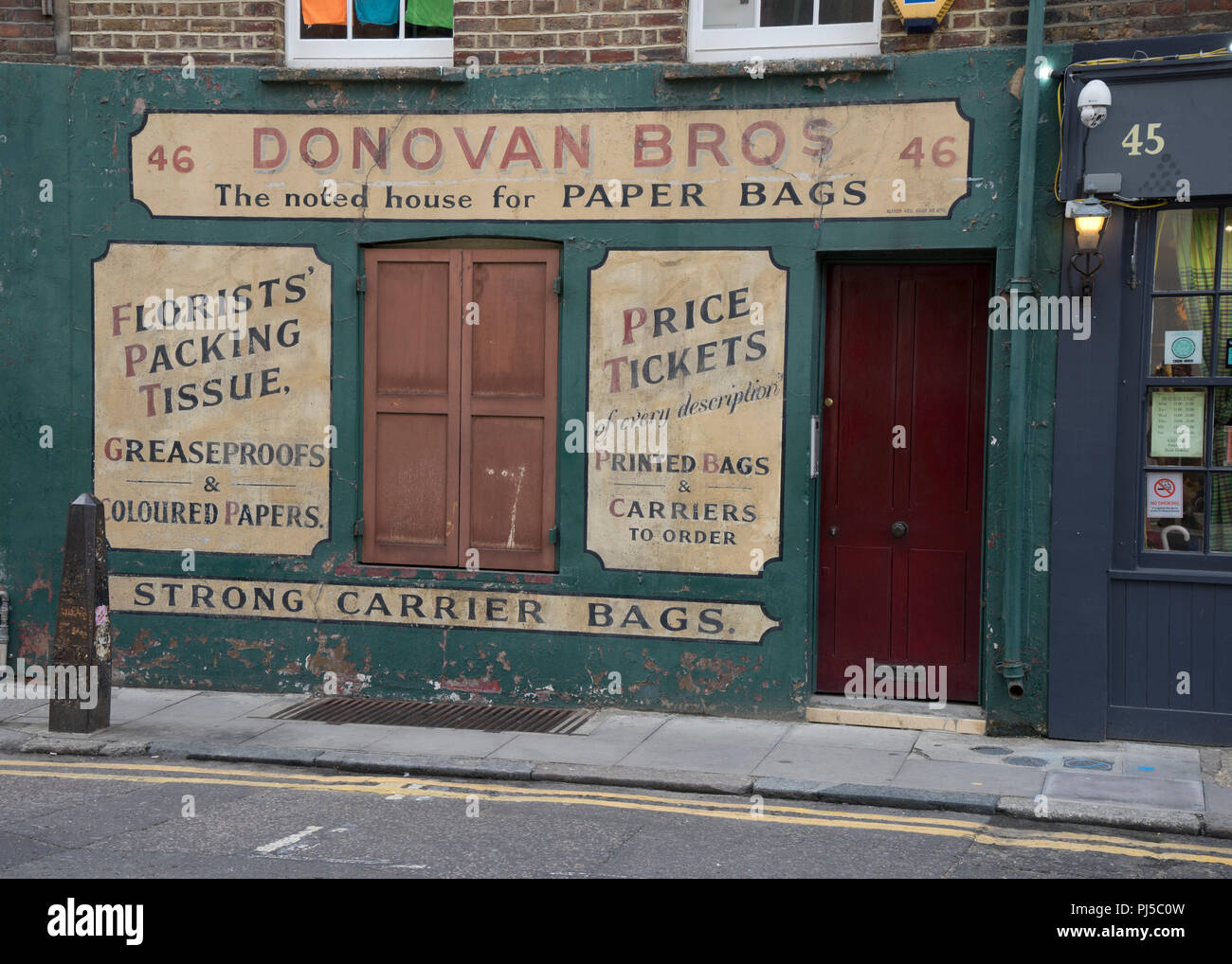 Old 1930s commercial signs on a wall by Spitalfields Church in the City ...